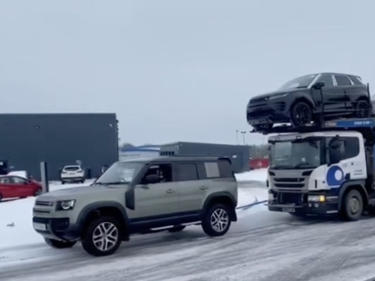 Watch a Land Rover Defender rescue a car transporter stuck in the snow ...