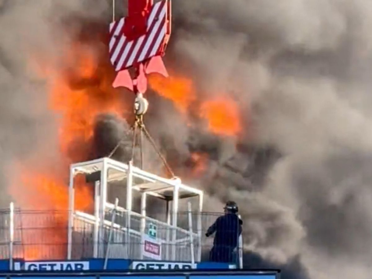 Workman trapped on burning high-rise building lifted to safety by crane ...