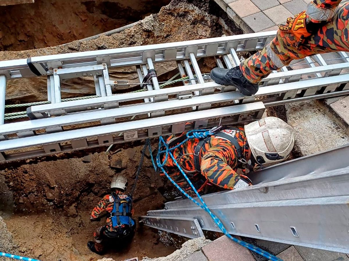 Woman plunges into 26ft hole after pavement collapses in Malaysian ...